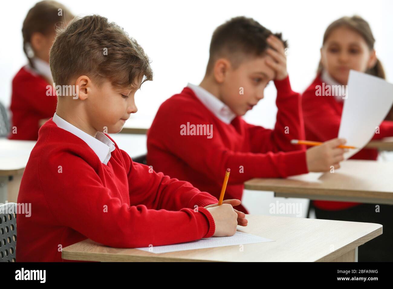 Pupils passing exam at school Stock Photo - Alamy
