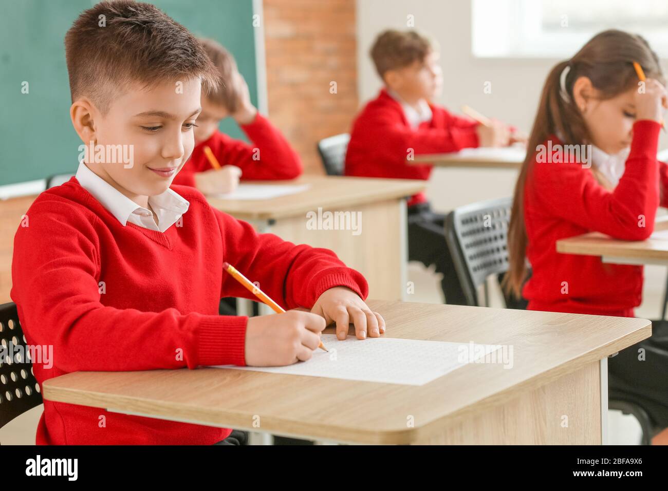 Pupils passing exam at school Stock Photo - Alamy