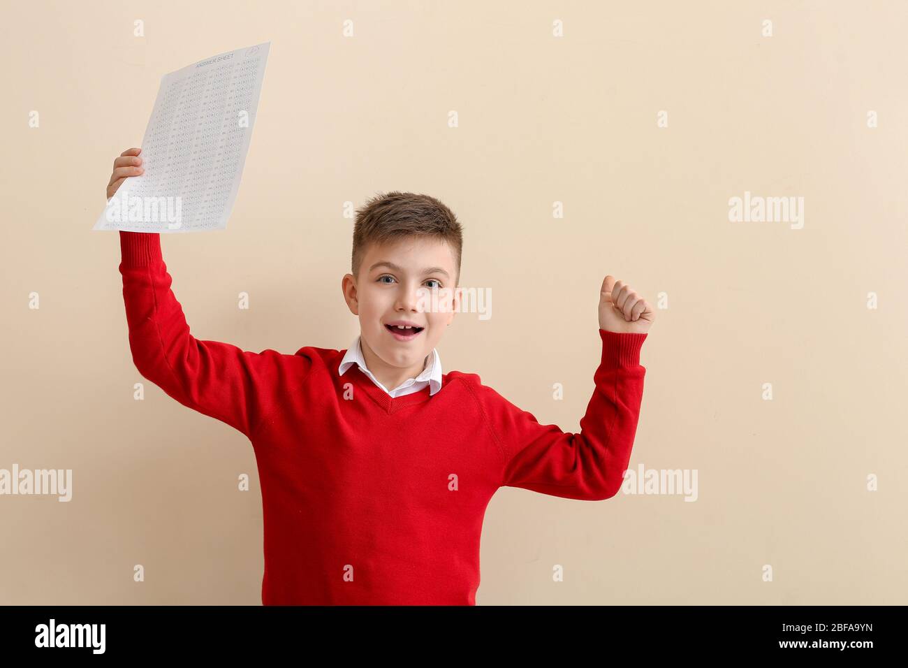 Pupil with answer sheet for school test on color background Stock Photo ...