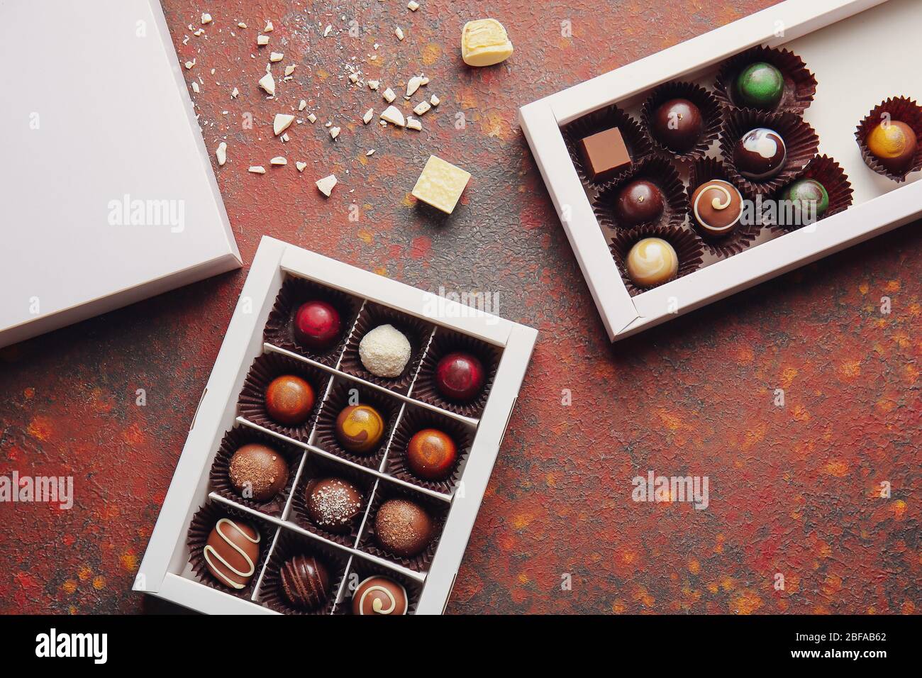 Boxes with delicious chocolate candies on grunge background Stock Photo ...