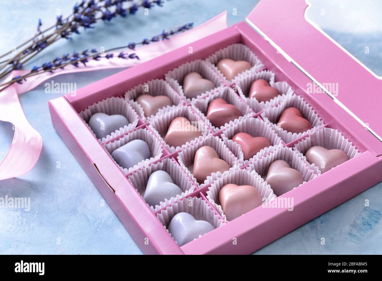 Box with delicious candies on color background Stock Photo - Alamy