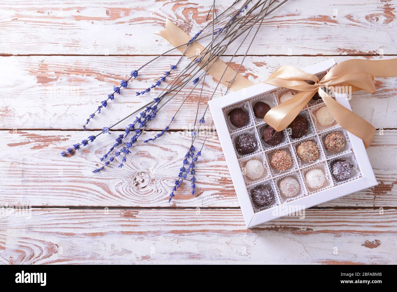 Box with delicious candies on white wooden background Stock Photo - Alamy