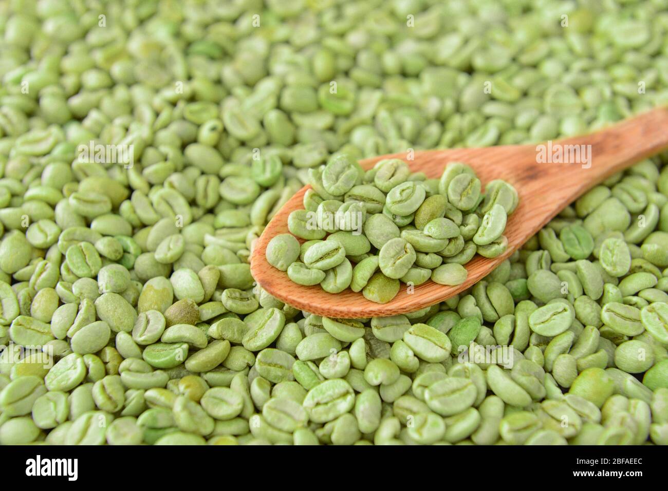 Spoon with green coffee beans, closeup Stock Photo - Alamy