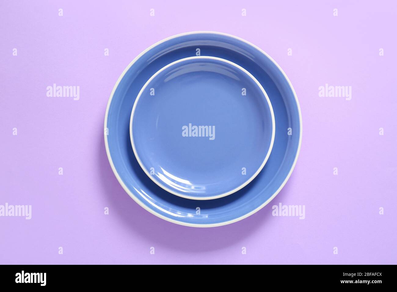 Clean plates on color background Stock Photo - Alamy