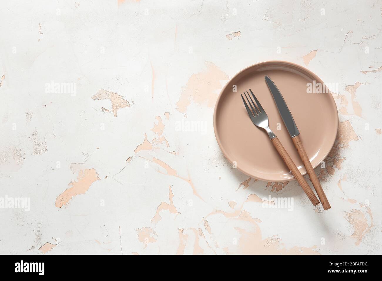 Clean plate and cutlery on light background Stock Photo - Alamy
