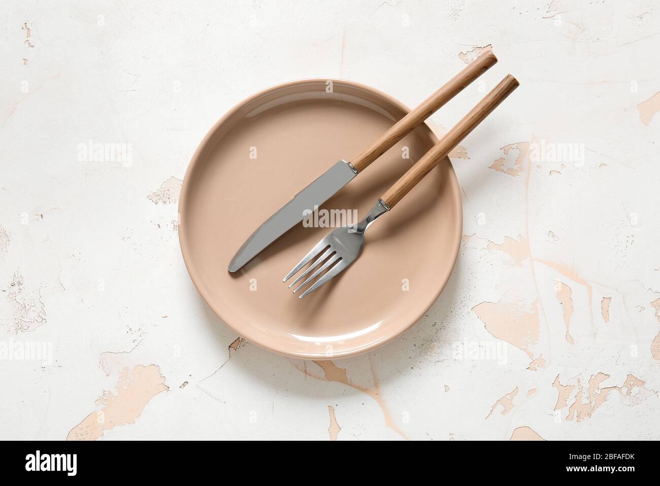 Clean plate and cutlery on light background Stock Photo - Alamy