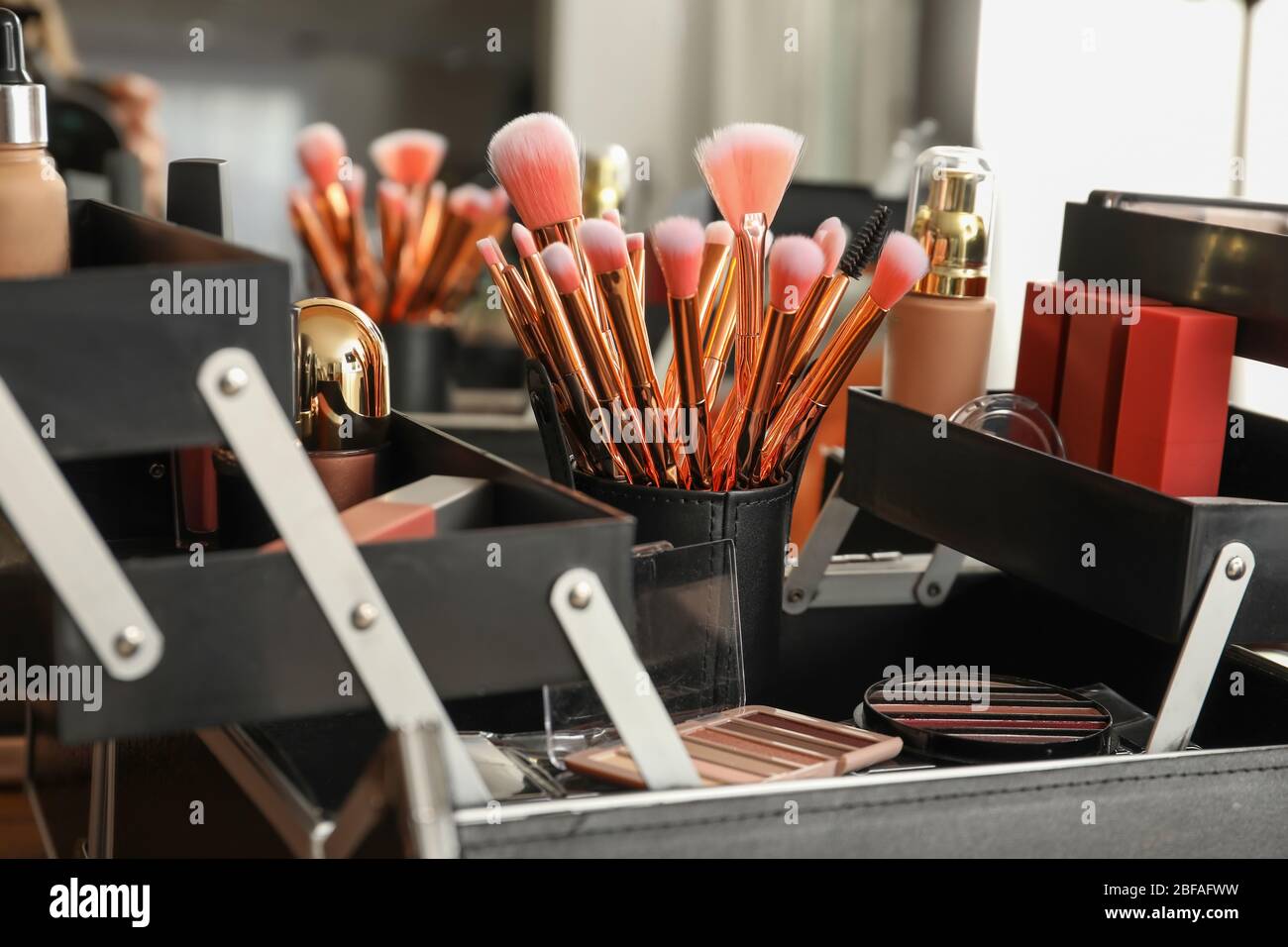 Box with set of brushes and decorative cosmetics on table of makeup ...