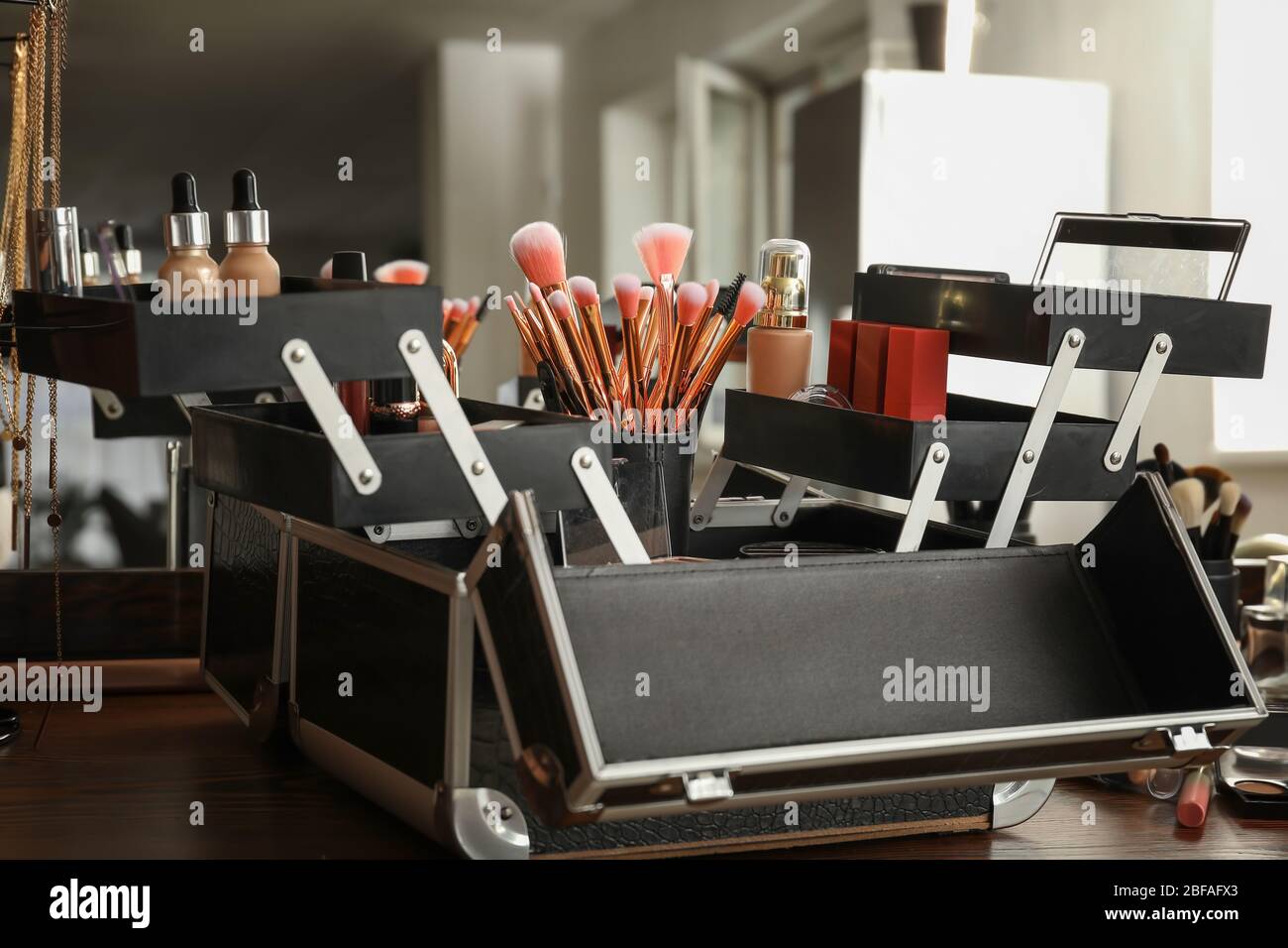 Box with set of brushes and decorative cosmetics on table of makeup ...