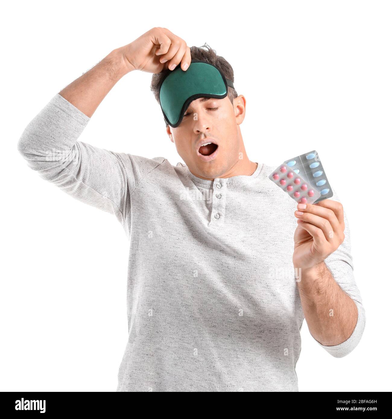 Tired man with sleeping pills on white background Stock Photo - Alamy