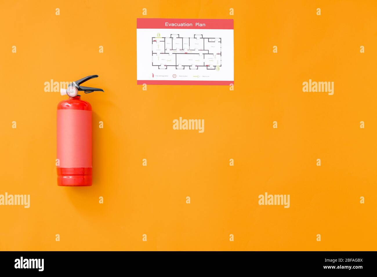 Fire extinguisher and evacuation plan on color background Stock Photo ...
