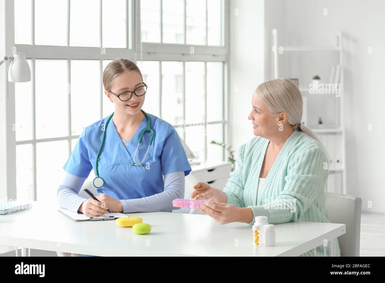 Doctor giving pills to patient in clinic Stock Photo - Alamy