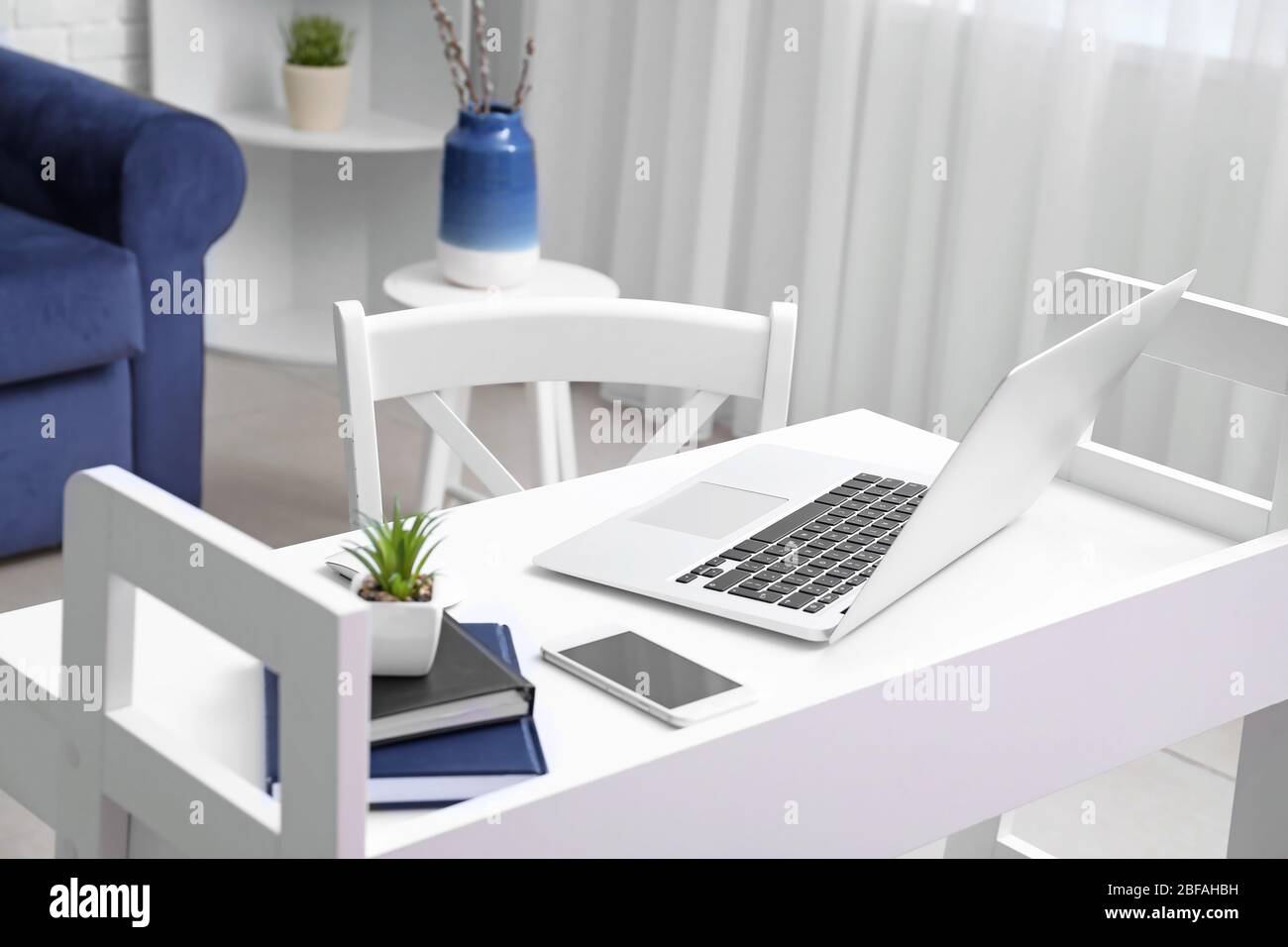 Modern laptop on workplace in room Stock Photo - Alamy
