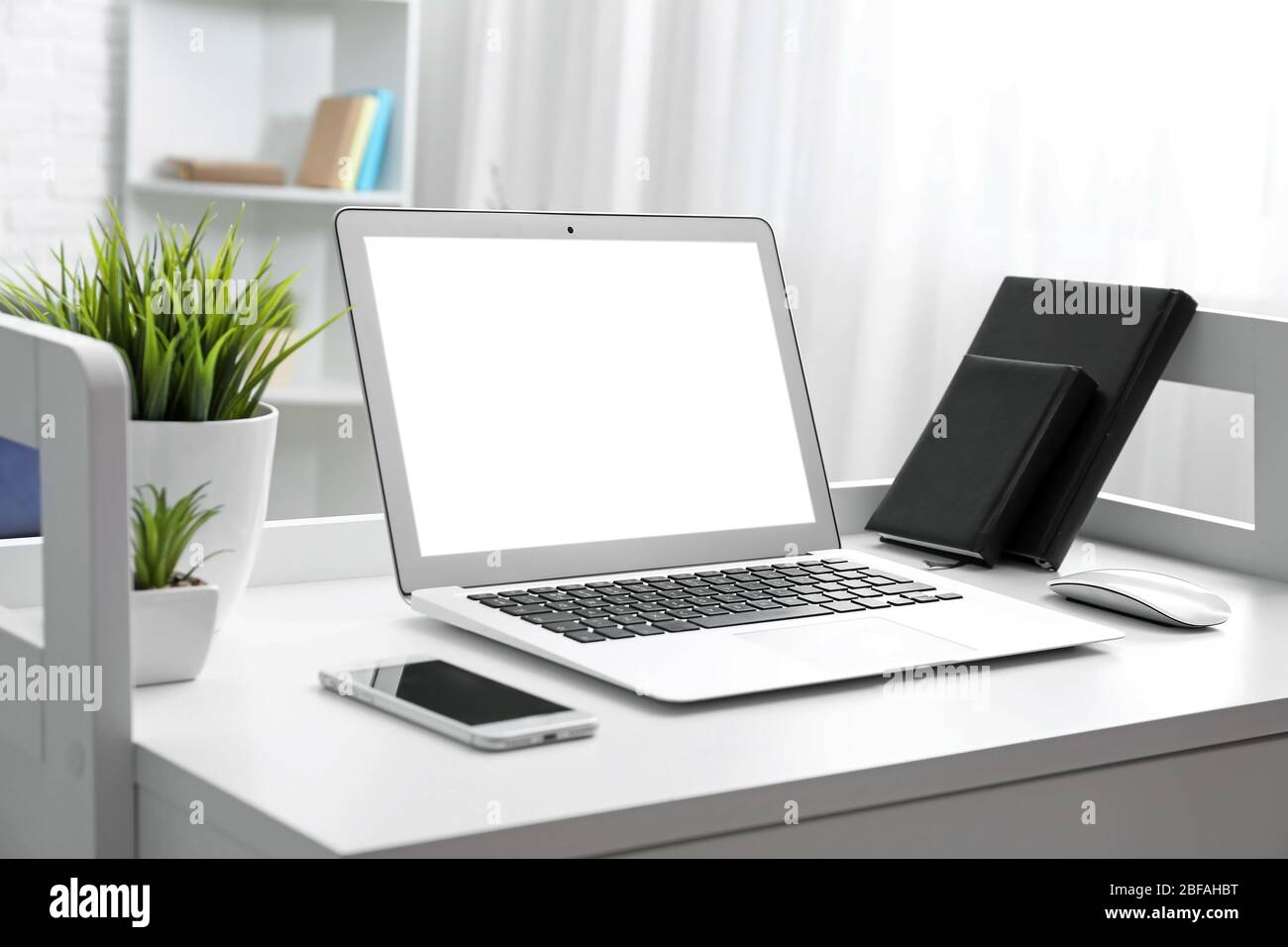 Modern laptop on workplace in room Stock Photo - Alamy