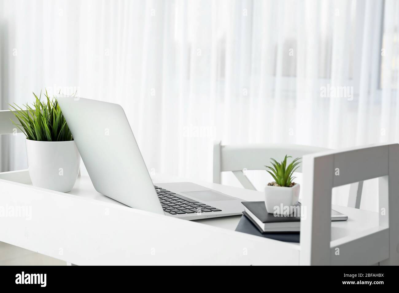 Modern laptop on workplace in room Stock Photo - Alamy