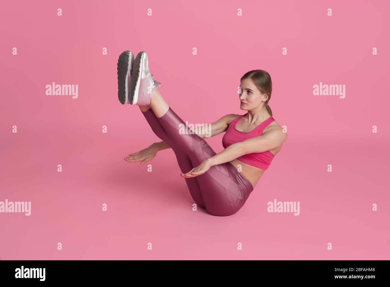ABS' crunches. Beautiful young female athlete practicing in studio ...