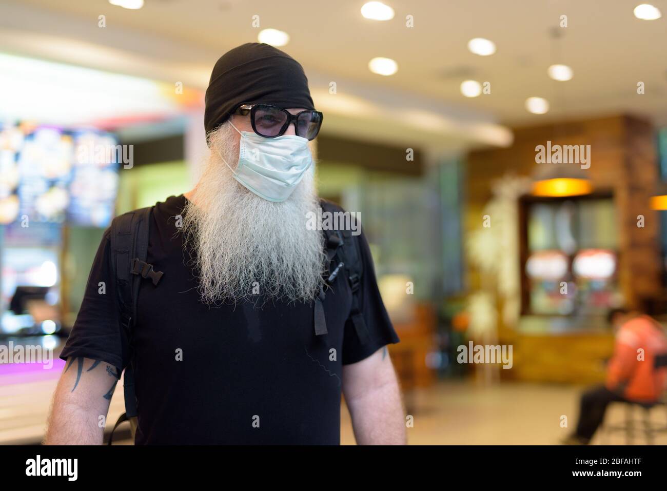Mature bearded hipster man as backpacker with mask and sunglasses ...