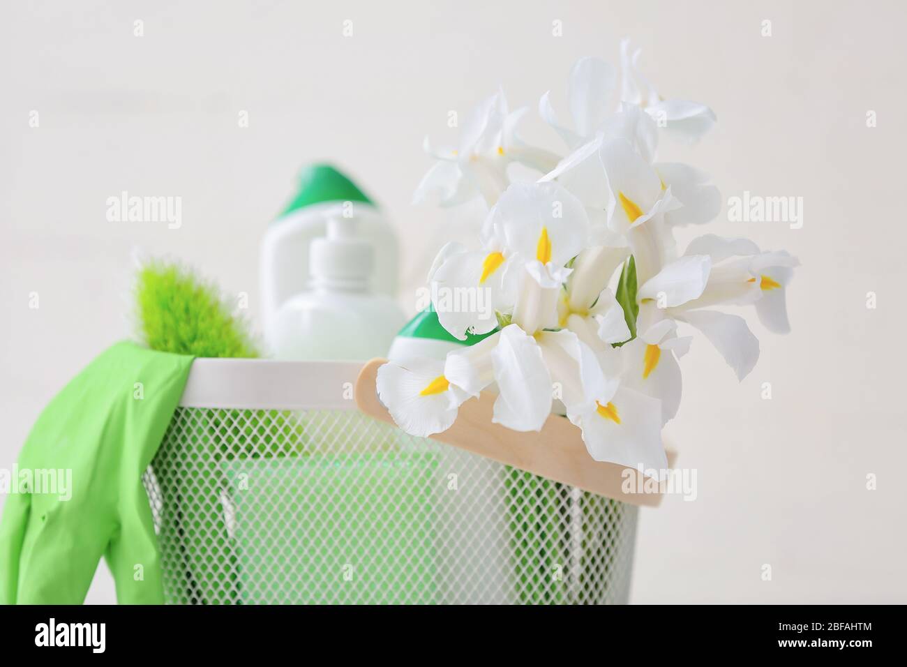 Set of cleaning supplies and spring flowers on white background ...