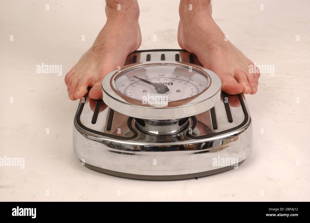 A young man weighs himself Stock Photo - Alamy