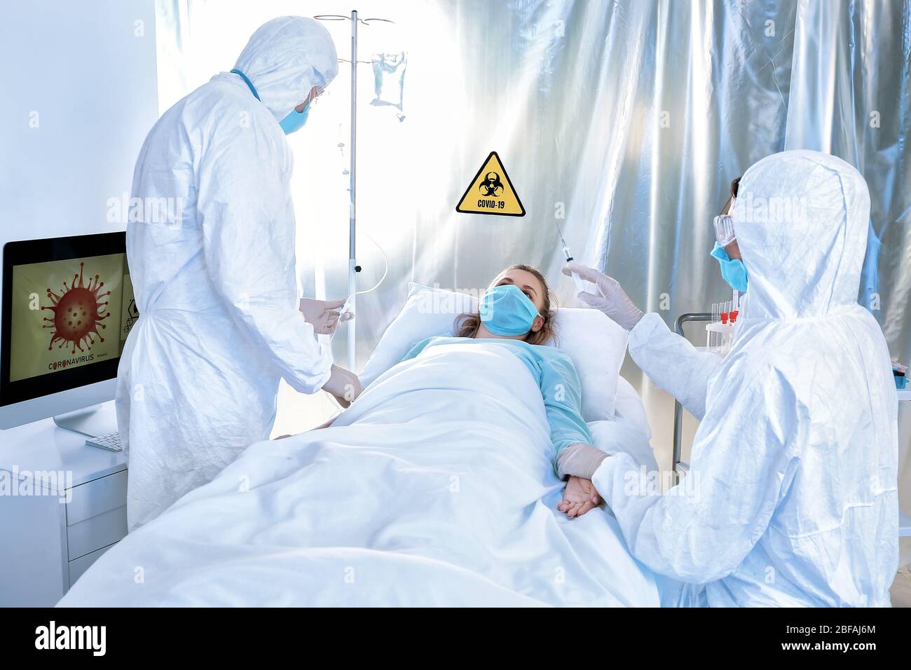 Doctors in biohazard suits working with patient in contagious isolation ...