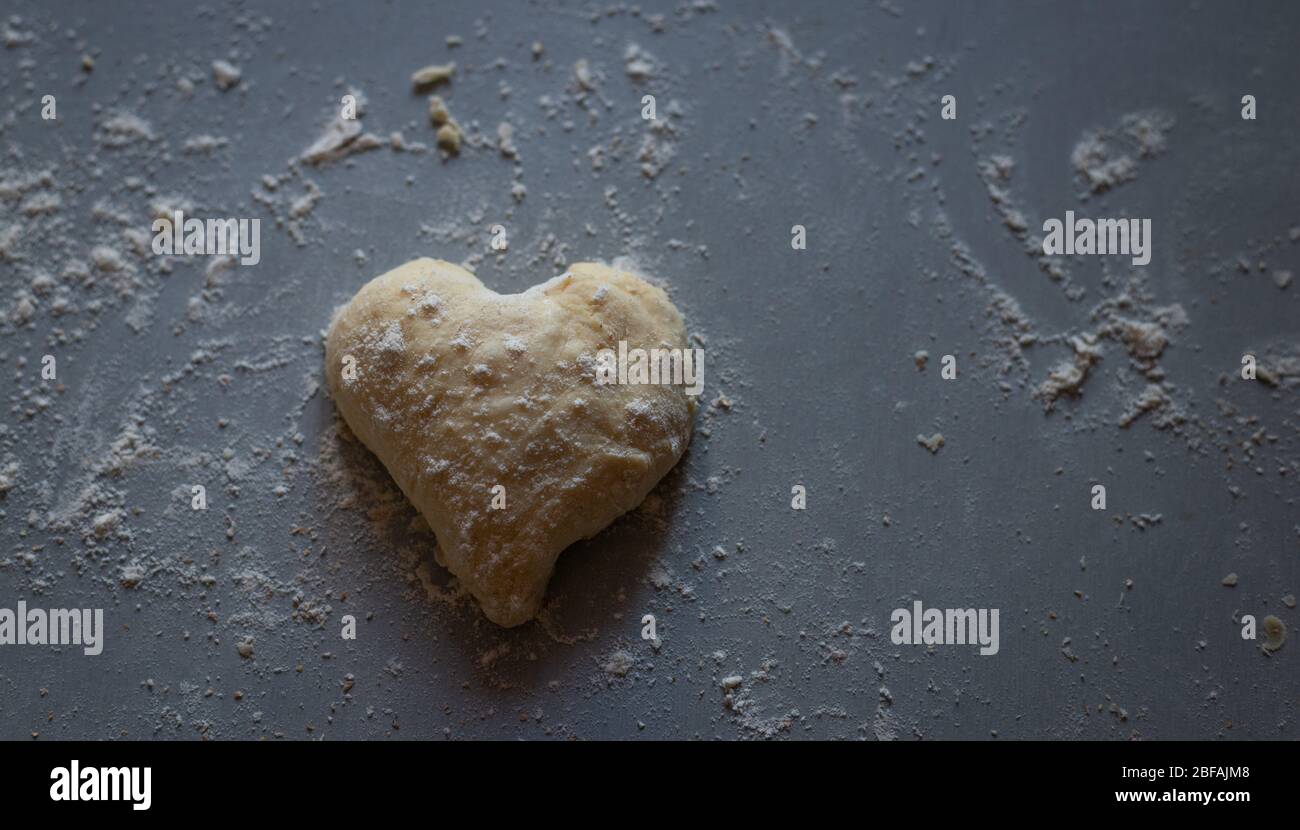 heart shaped Bread dough on floured board ,making bread rolls at home ...