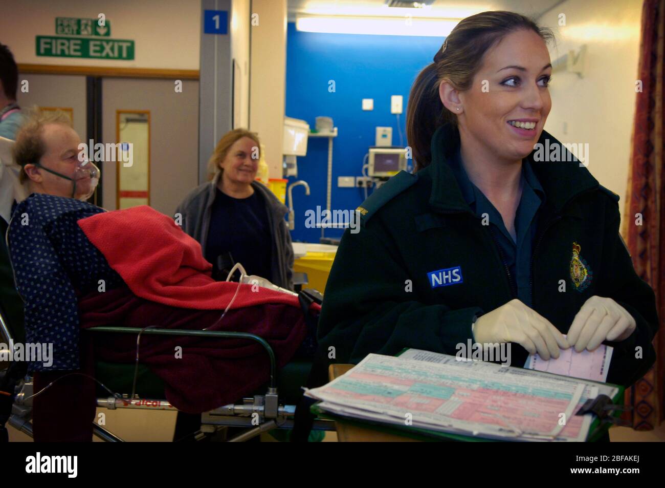 An paramedic 'books' a bed ridden patient into hospital Stock Photo - Alamy
