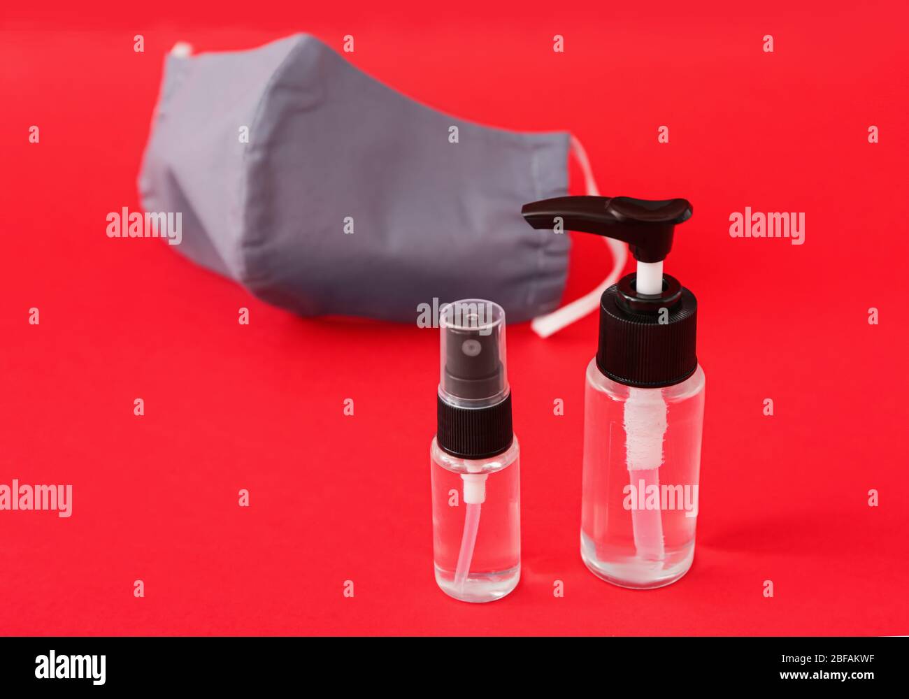 Bottles with disinfectant and protective mask on color background Stock ...