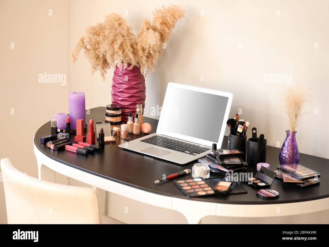 Set of decorative cosmetics and laptop on table of makeup artist in ...