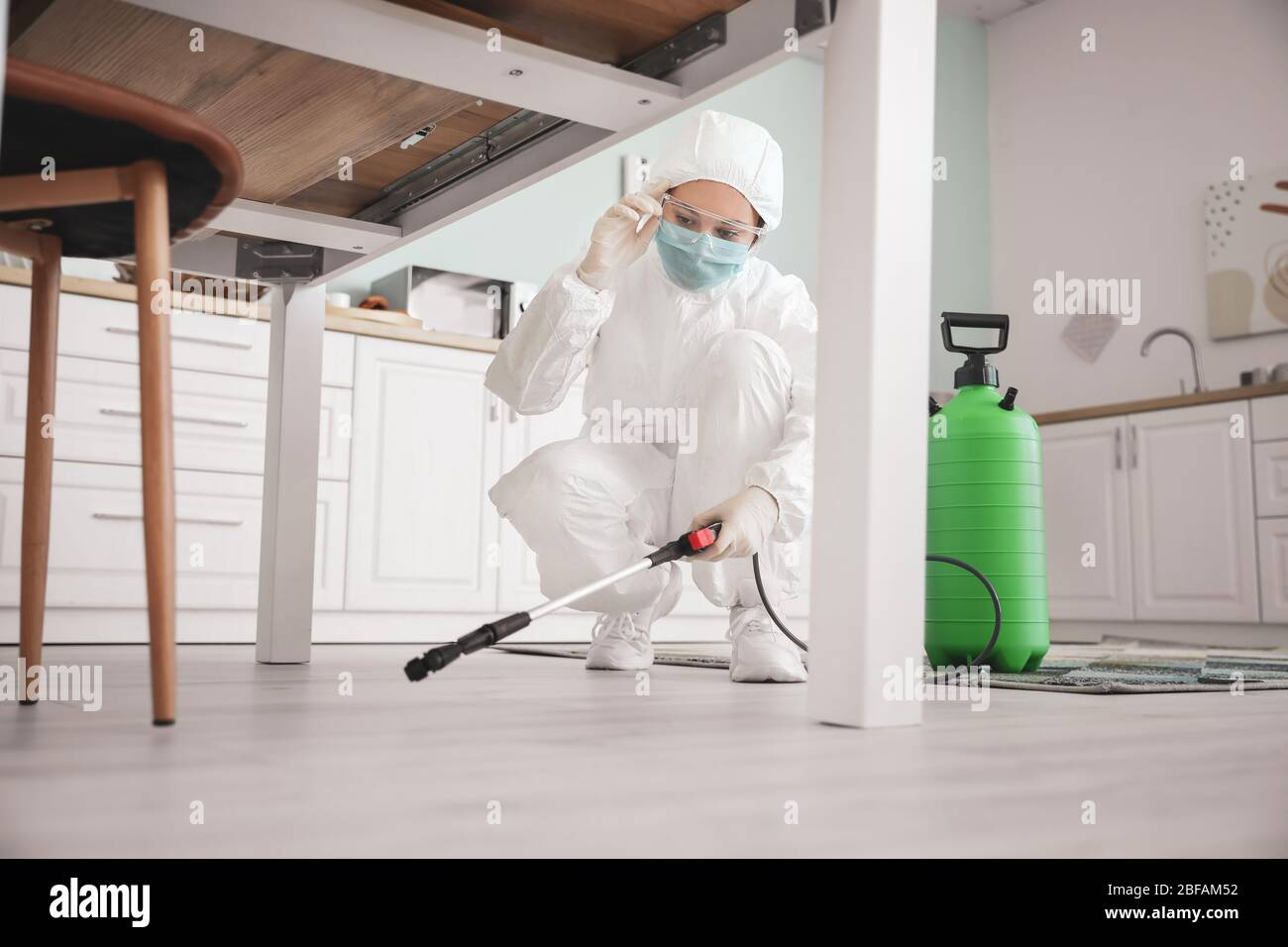 Worker in biohazard suit disinfecting house Stock Photo - Alamy