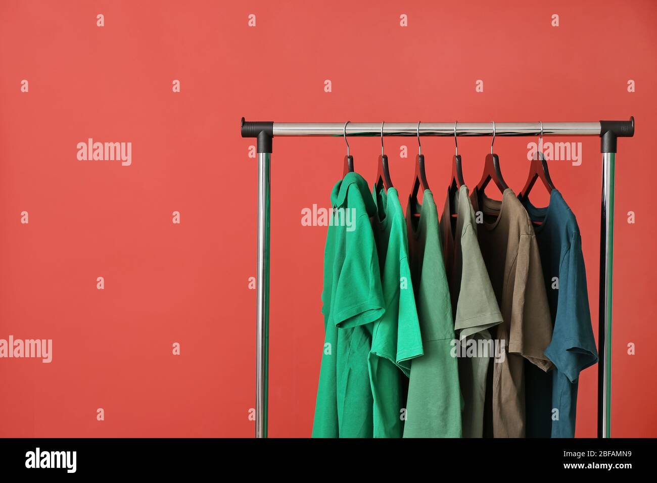 Rack with modern clothes on color background Stock Photo - Alamy
