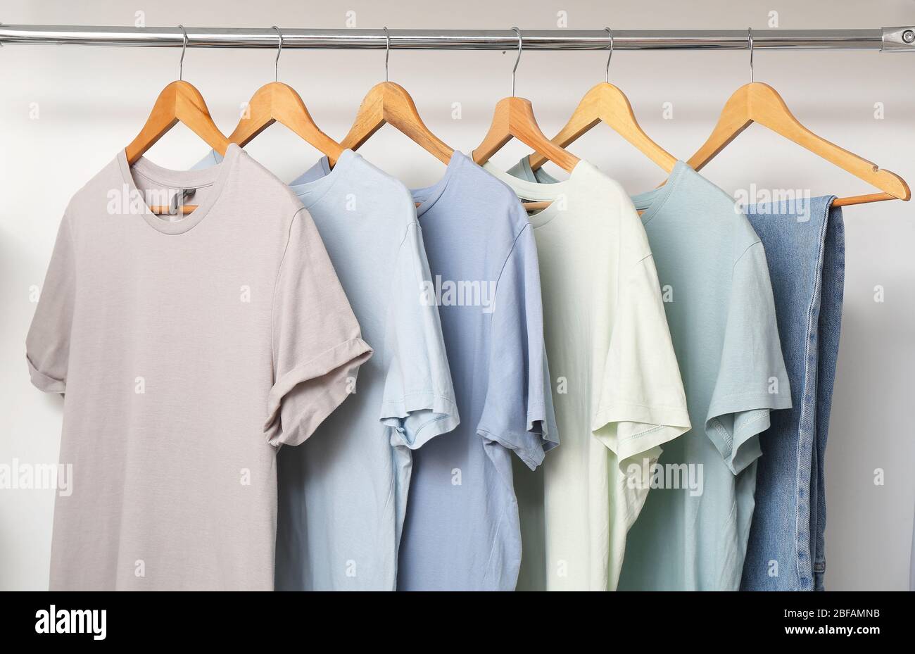 Stylish male clothes on hanger in wardrobe Stock Photo - Alamy