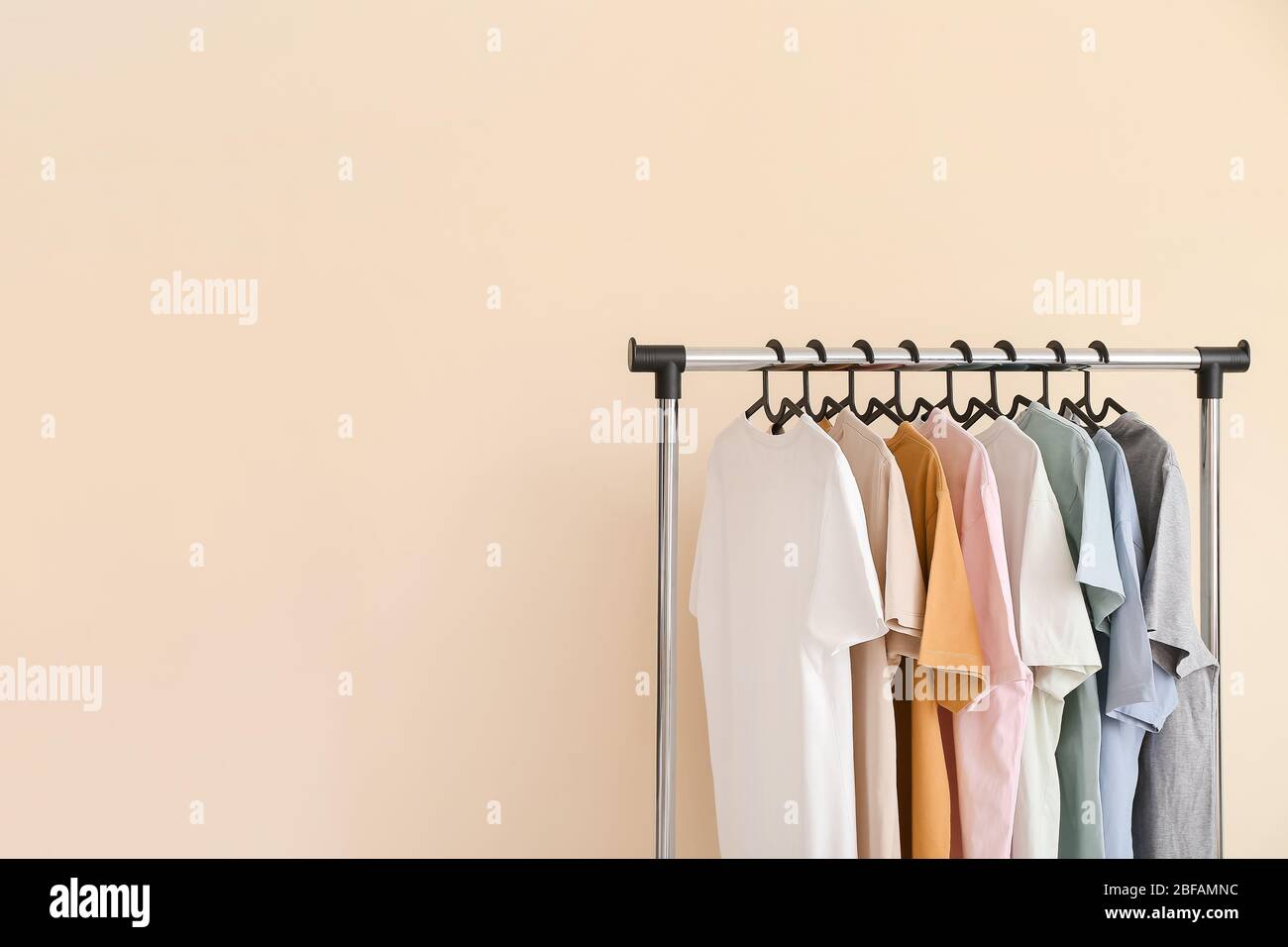 Rack with modern clothes on color background Stock Photo - Alamy