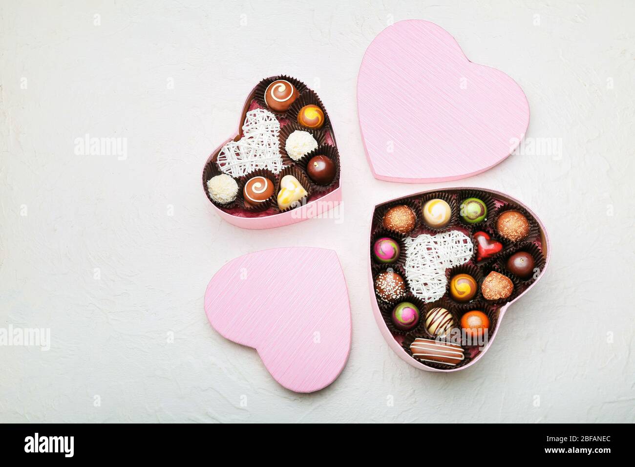 Heart-shaped boxes with delicious candies on white background Stock ...