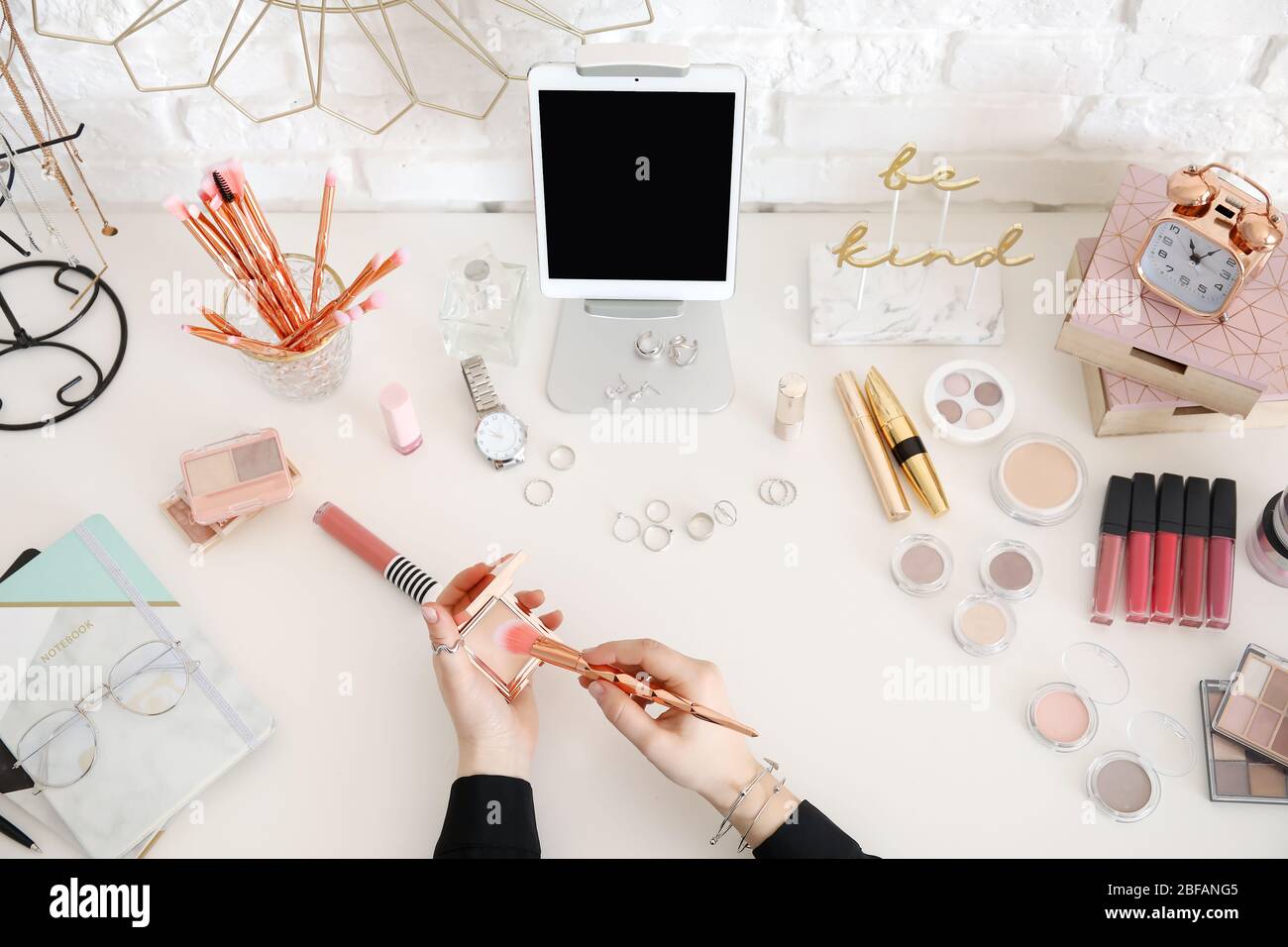 Makeup artist at table with modern tablet computer and cosmetics Stock ...