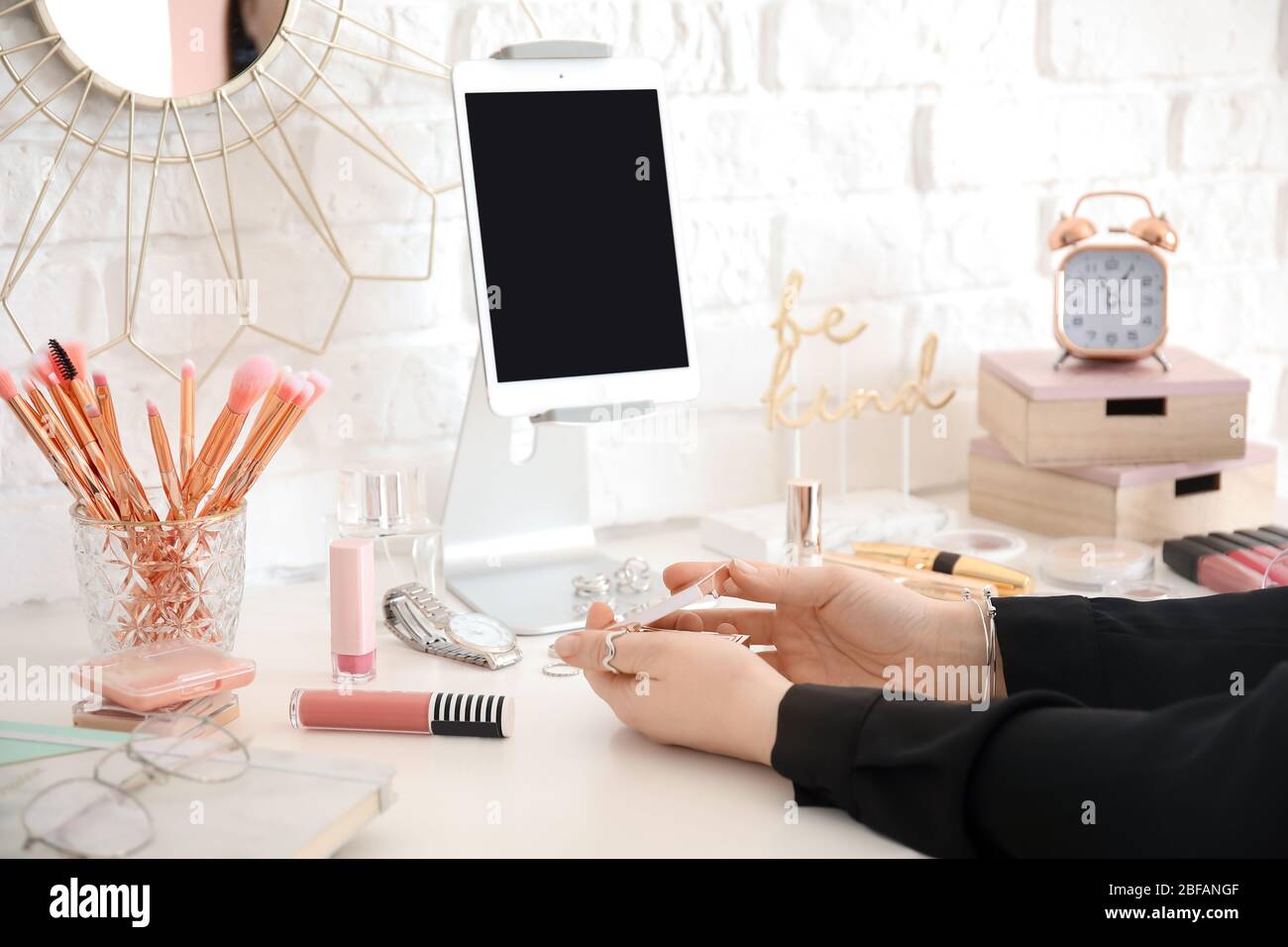 Makeup artist at table with modern tablet computer and cosmetics Stock ...