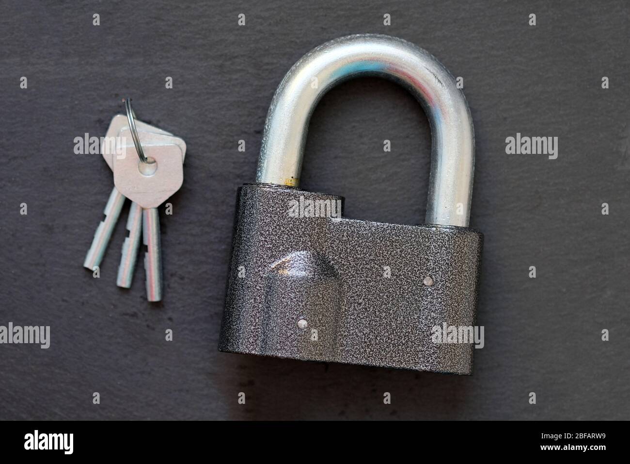 A padlock with a thick handle and three steel keys. Large padlock on a ...