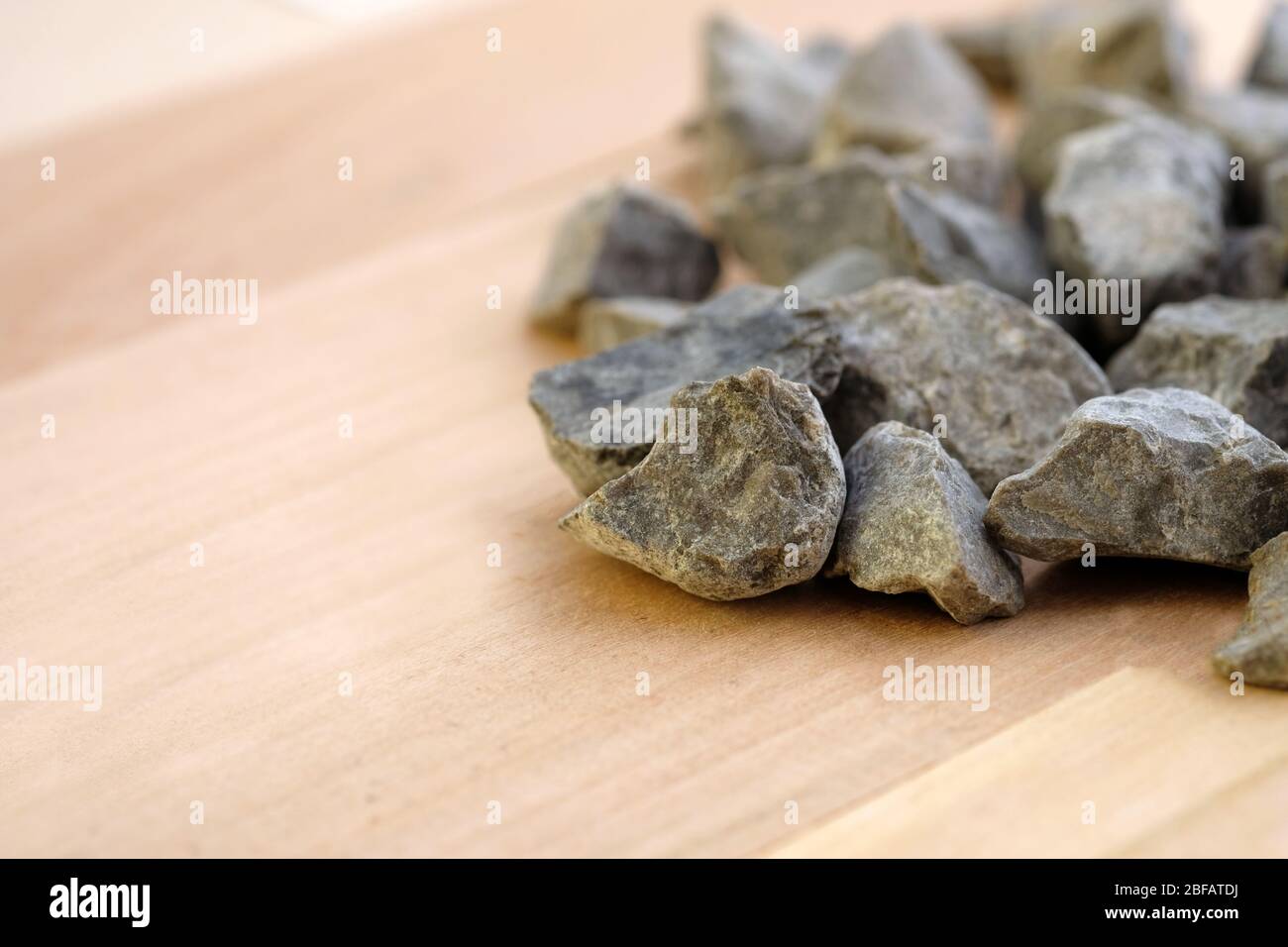 Gray silicon stones on a wood background. Flint natural stone for ...