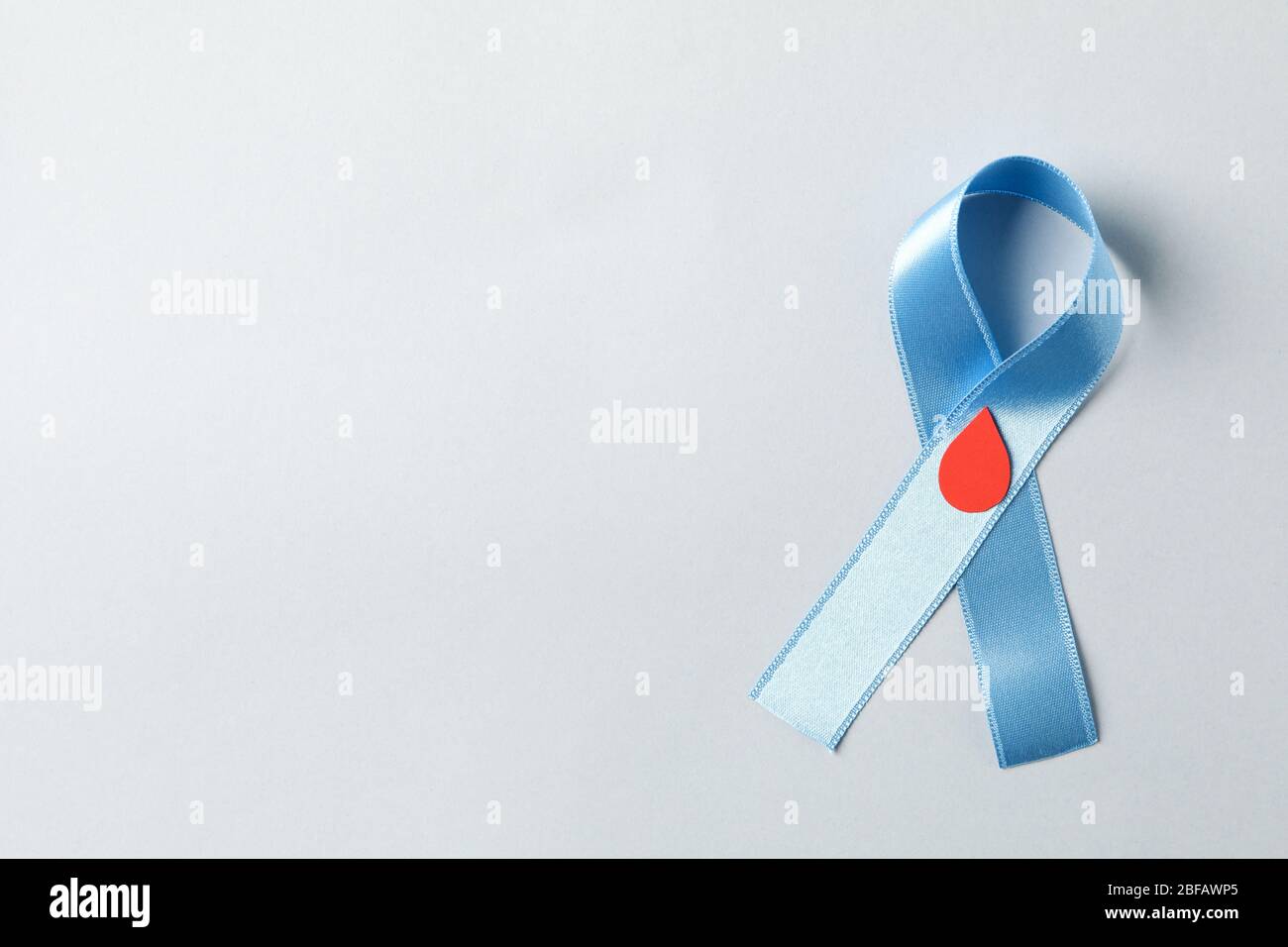Diabetes. Blue awareness ribbon with decorated blood drop on white ...