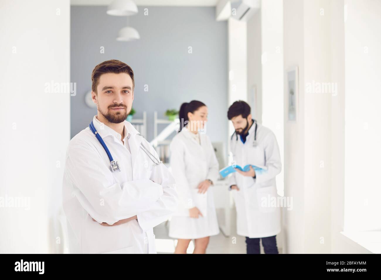 A male practicing doctor with a stethoscope against the background of a ...