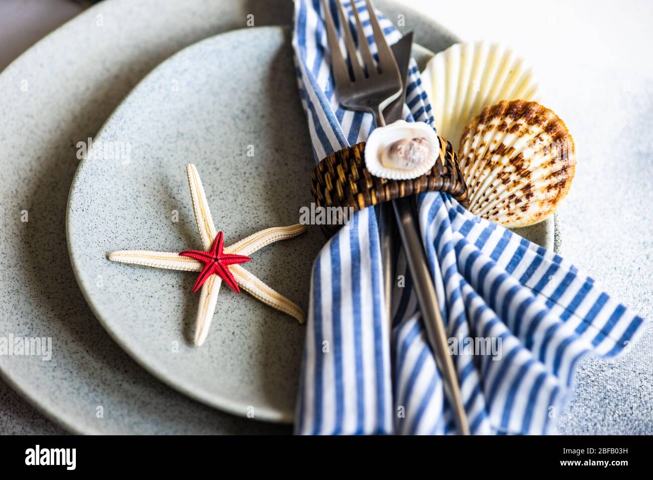 Summer table setting with plates and cutlery decorated with sea stars ...