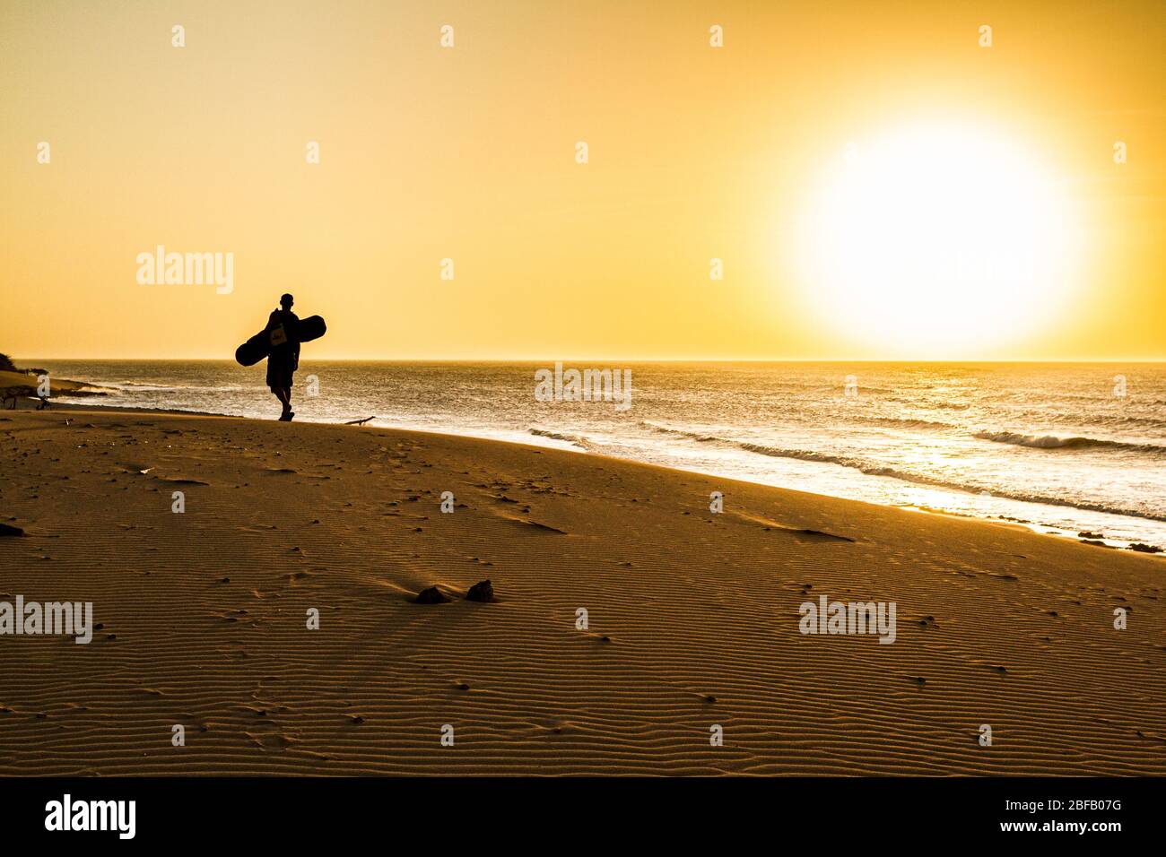 Silhouette of a man walking on Medanos Blancos Beach at sunset, in ...