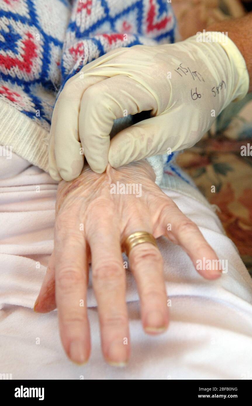 Paramedic holding elderly patients hand Stock Photo - Alamy