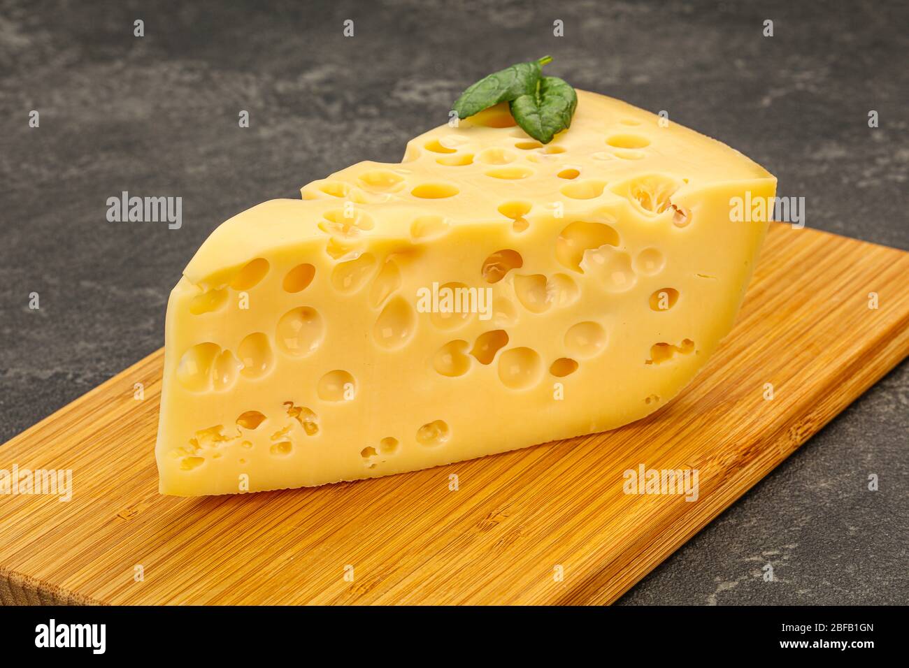 Maasdam cheese - dairy yellow triangle with holes Stock Photo - Alamy
