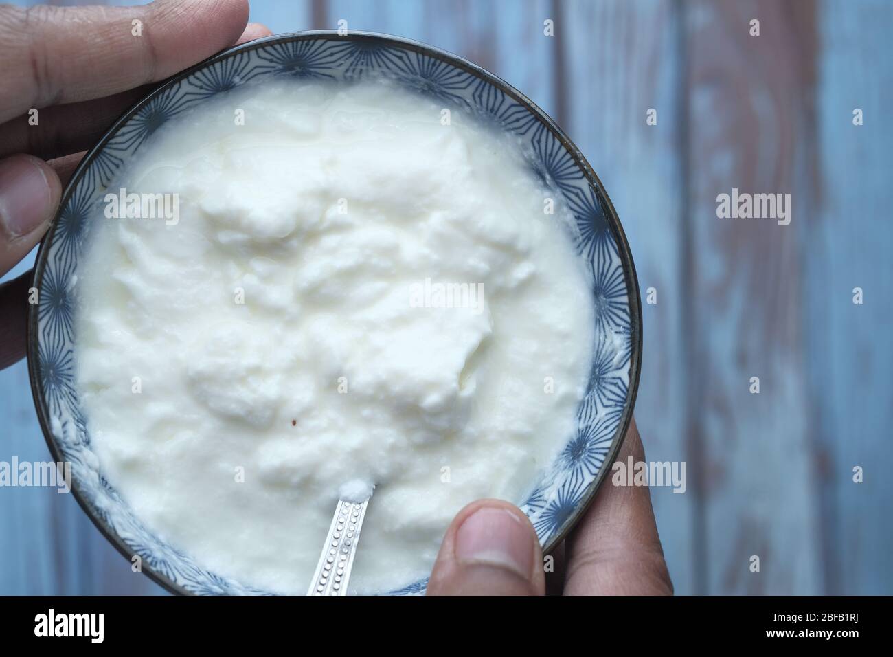 Man hand holding bowl of greek yogurt Stock Photo - Alamy