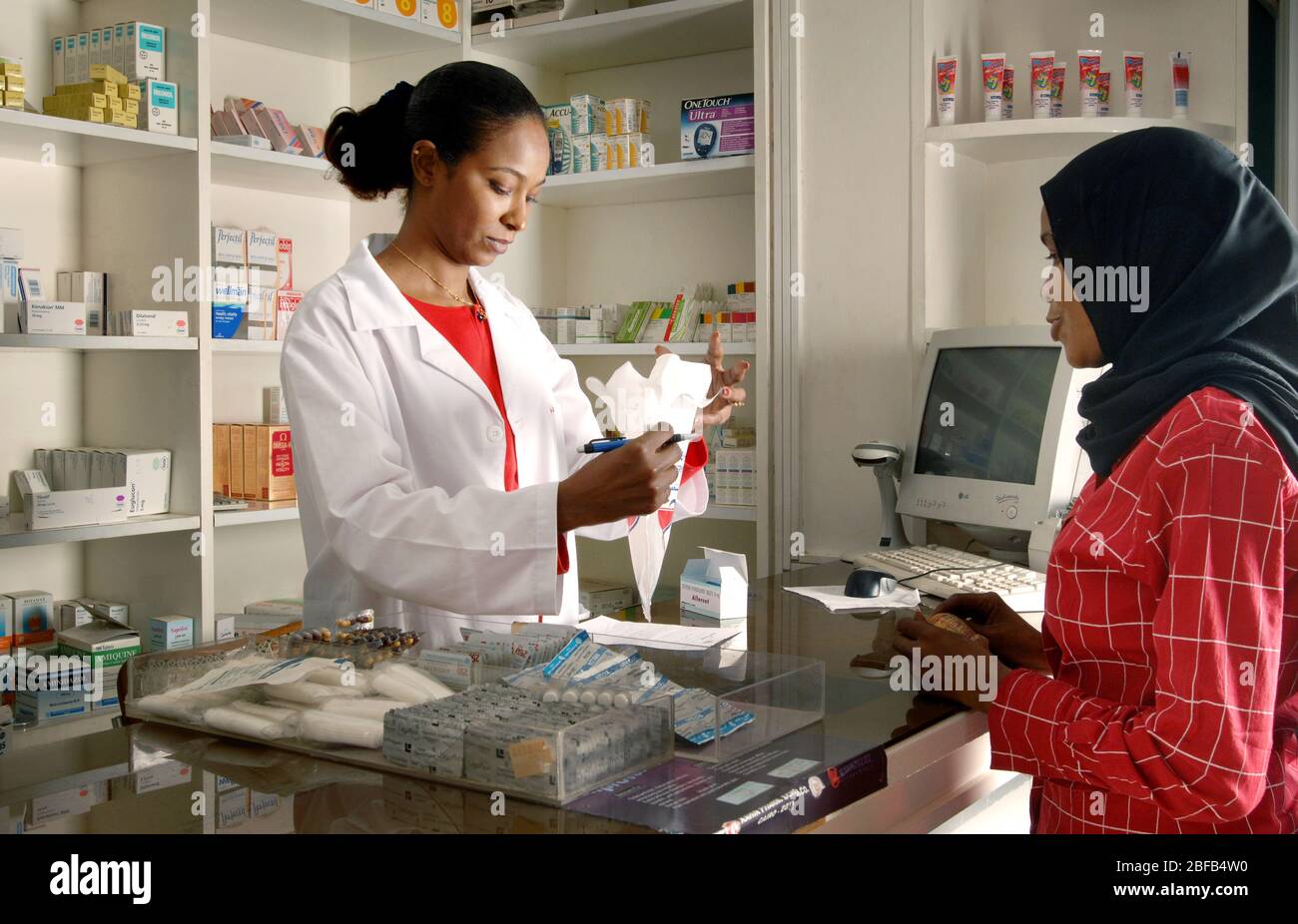 A female pharmacist supplies a patient collecting her prescription ...