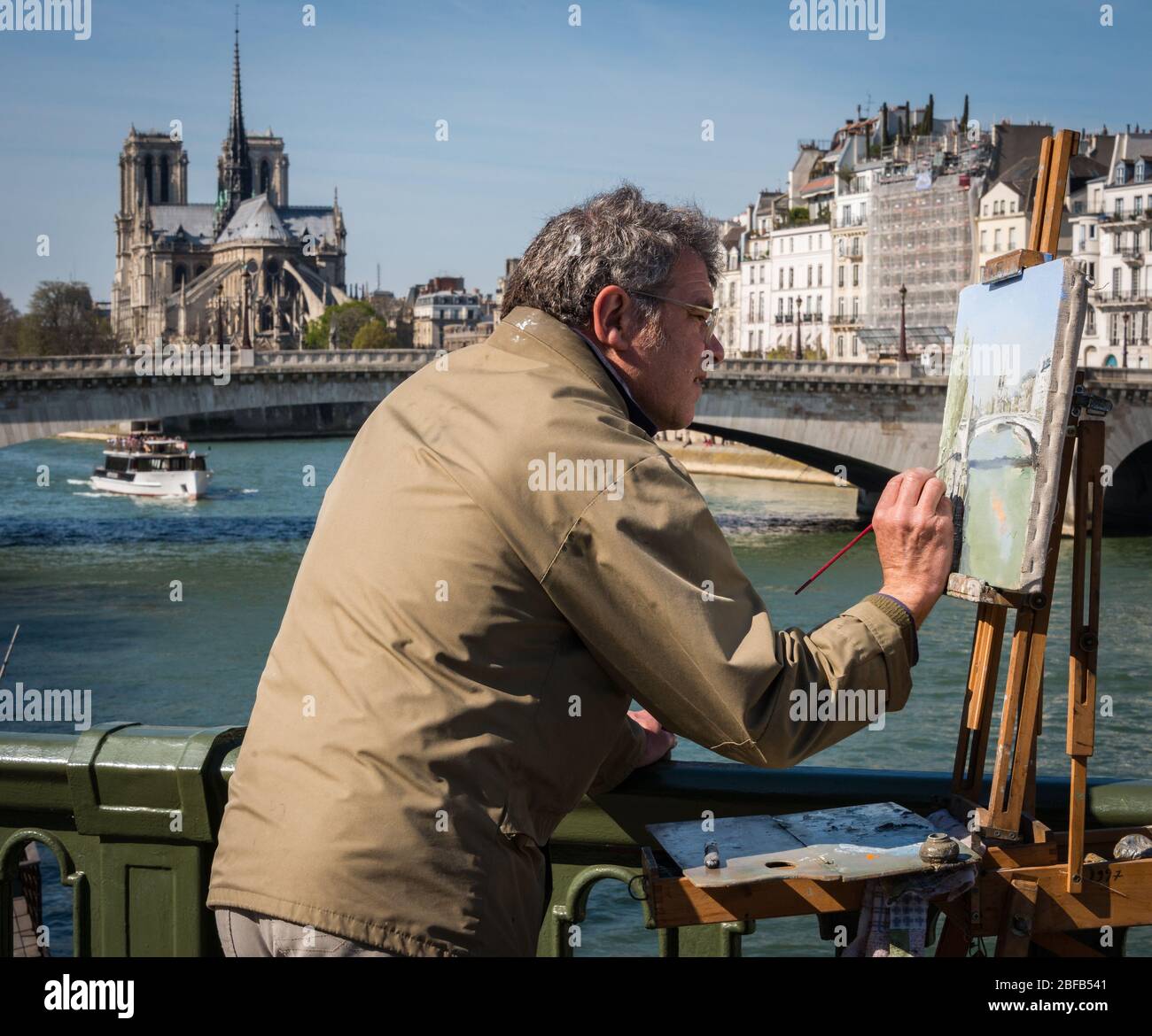 Paris, France; March 2014: Artist at work on a painting of the Seine ...