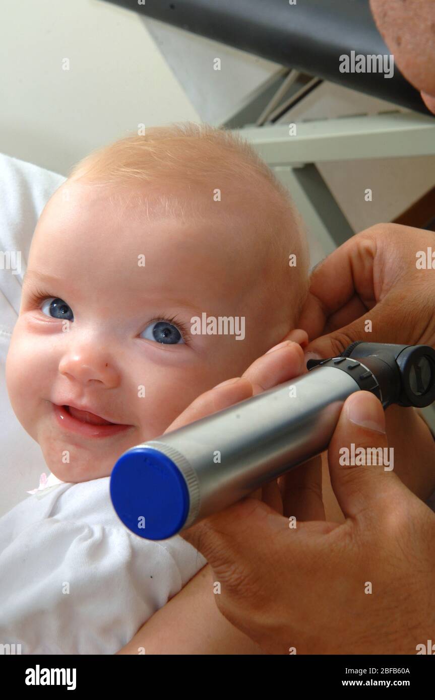 A GP uses an otoscope to examine the inside of a baby's ear Stock Photo ...