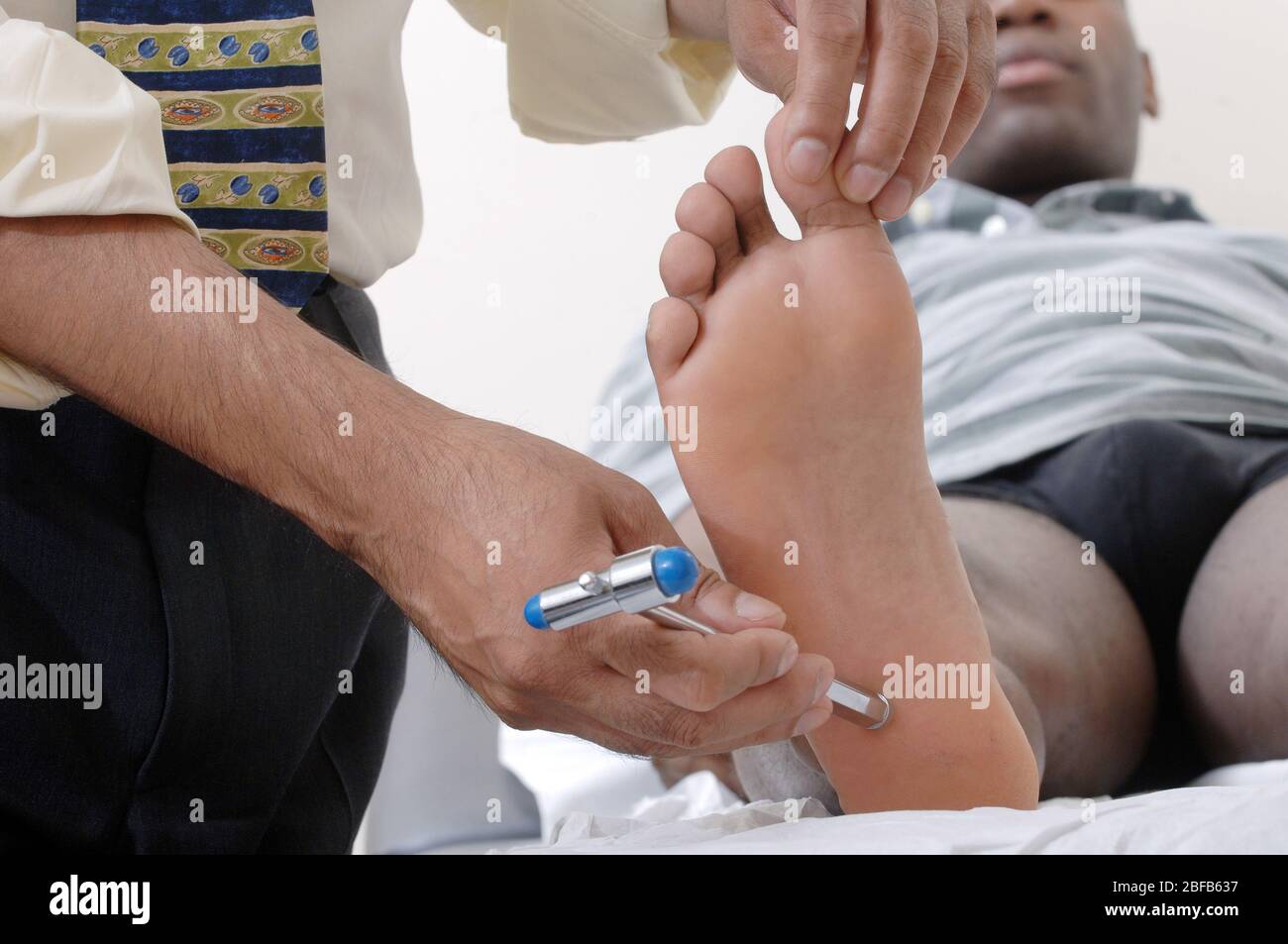 A GP test a patient's reflex in their foot(Model released Stock Photo ...