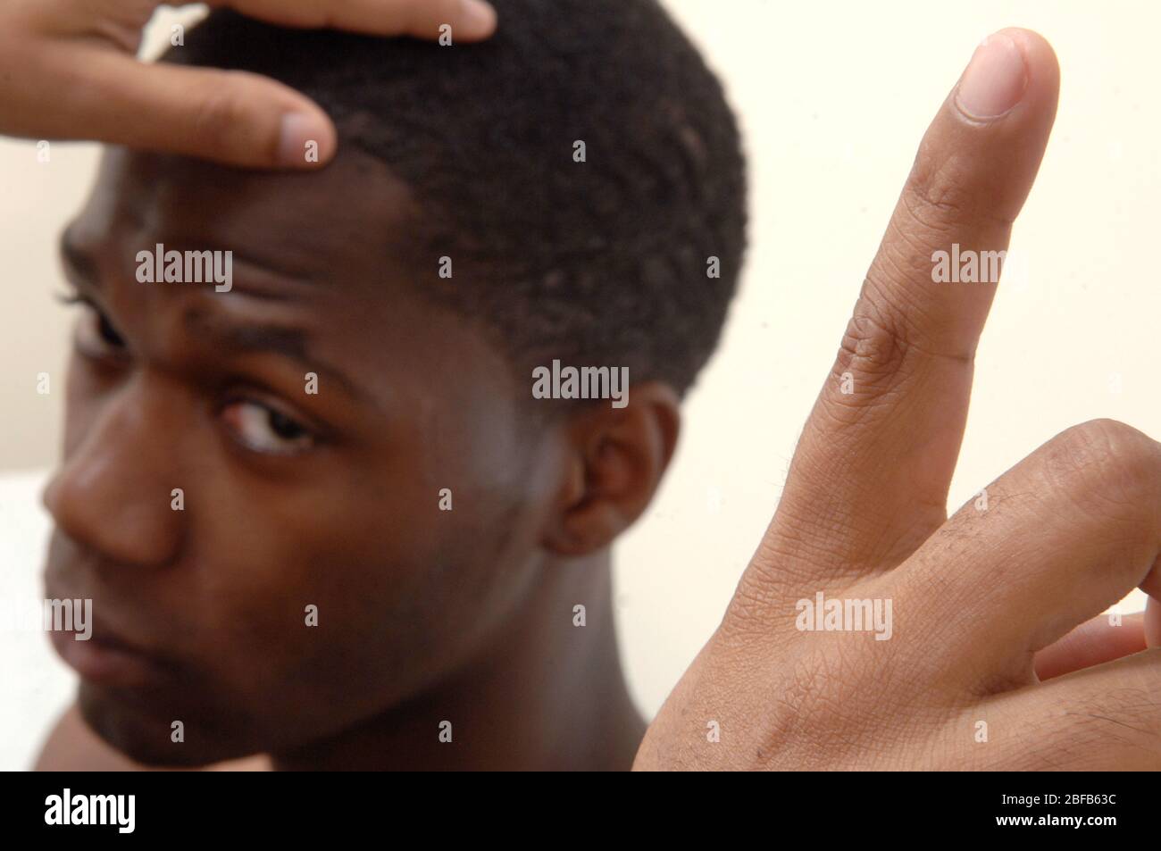 A GP performs the ‘follow my finger’ eye test on a young male patient ...