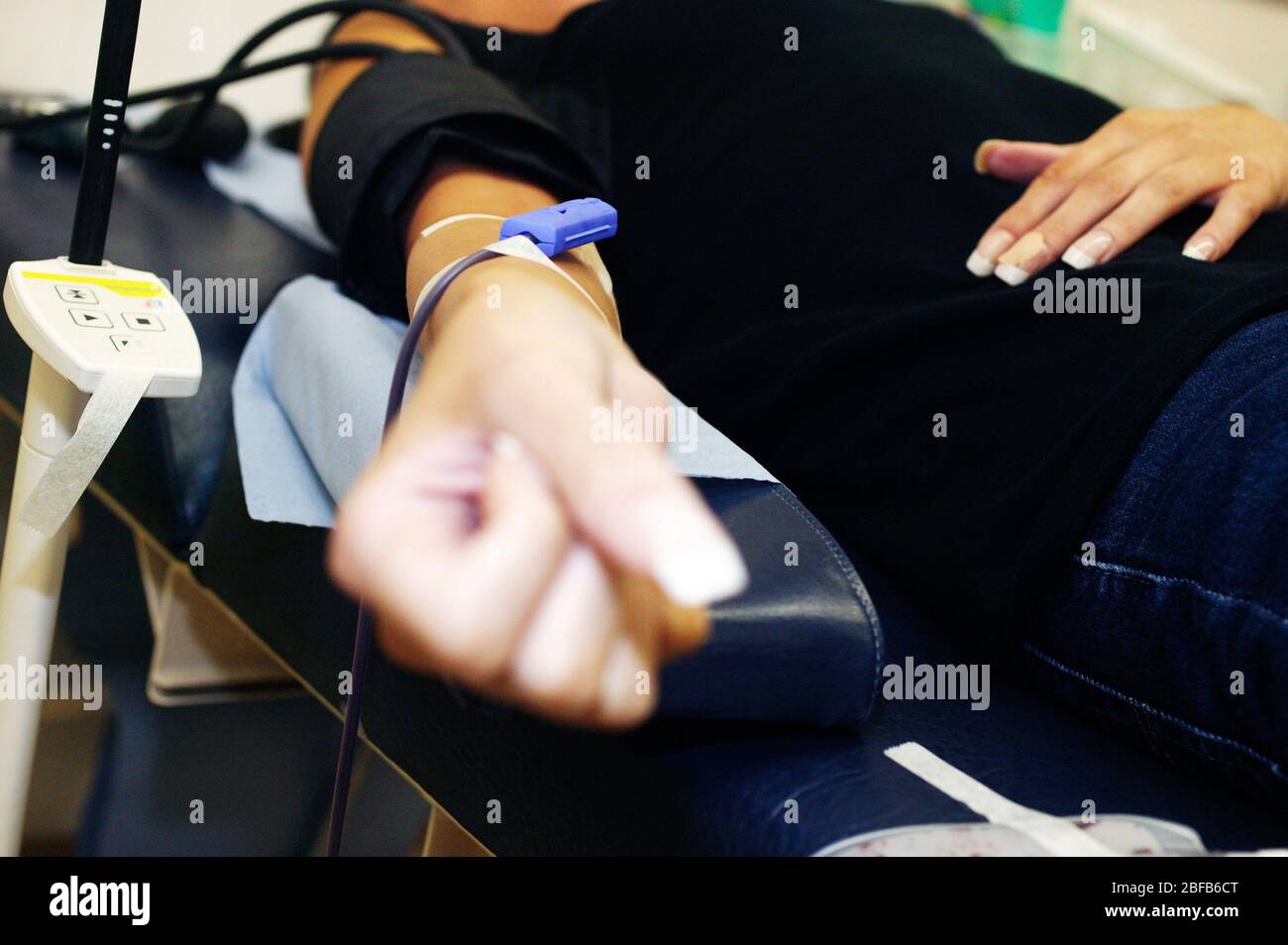 A female blood donor squeezing her hand to maximise circulation in her ...