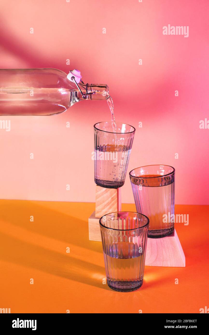 Bright summer design concept with clear water. Pour water from a bottle ...